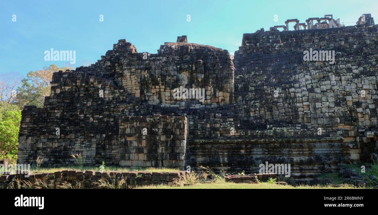 Medieval stone building ruins nestled in a Cambodian forest on a bright ...