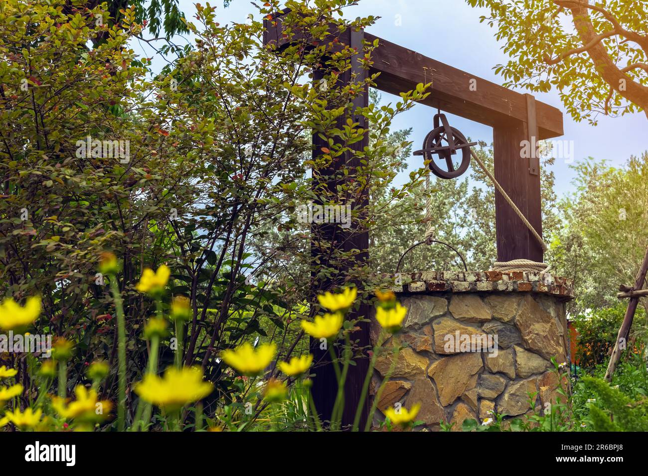 Beautiful artesian well made by stones and wheel pulley with metal ...