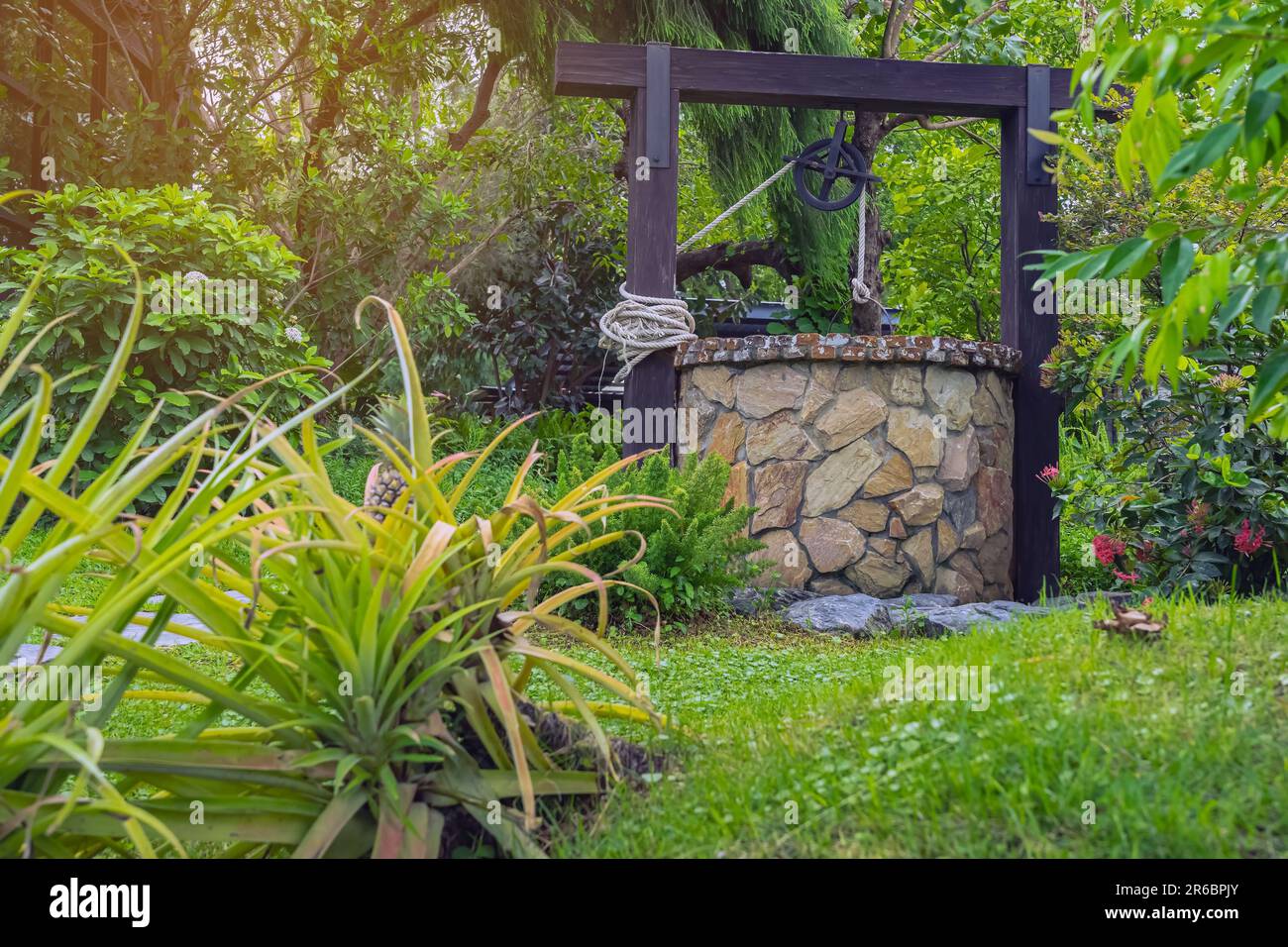 Beautiful artesian well made by stones and wheel pulley with metal ...