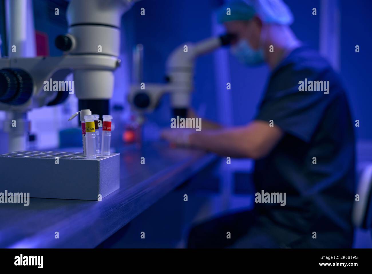 Laboratory worker examining samples under microscope in clinic Stock ...