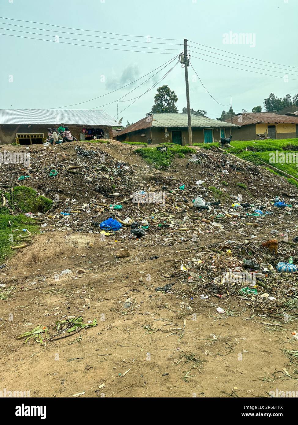 Uganda, Africa - March 25, 2023: Children sit on a pile of trash in a ...