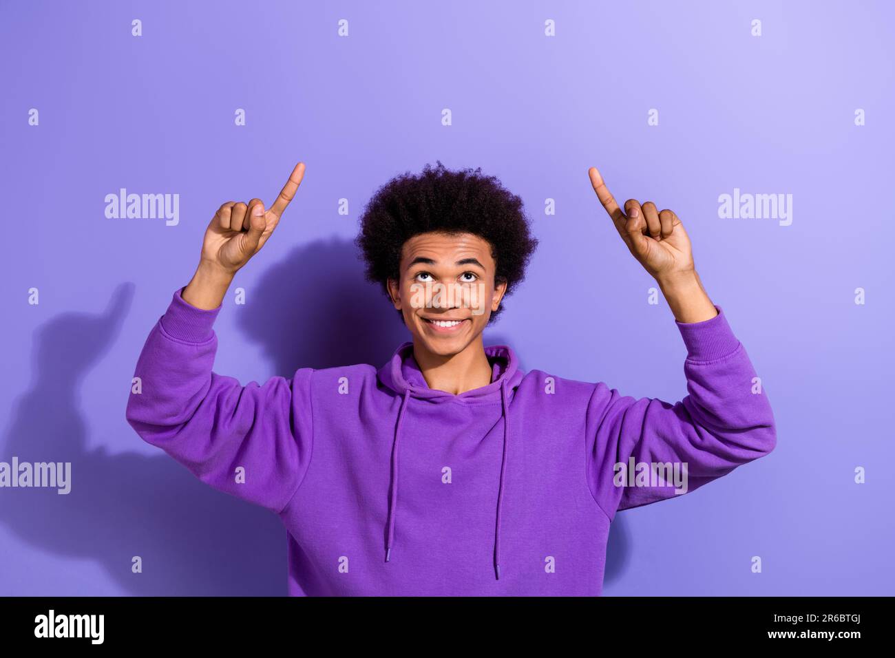 Photo of cheerful young person beaming smile look indicate fingers up ...