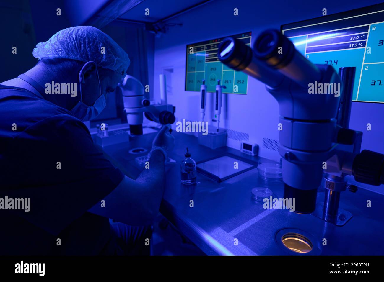 Technician working on in vitro fertilization of egg in special ...