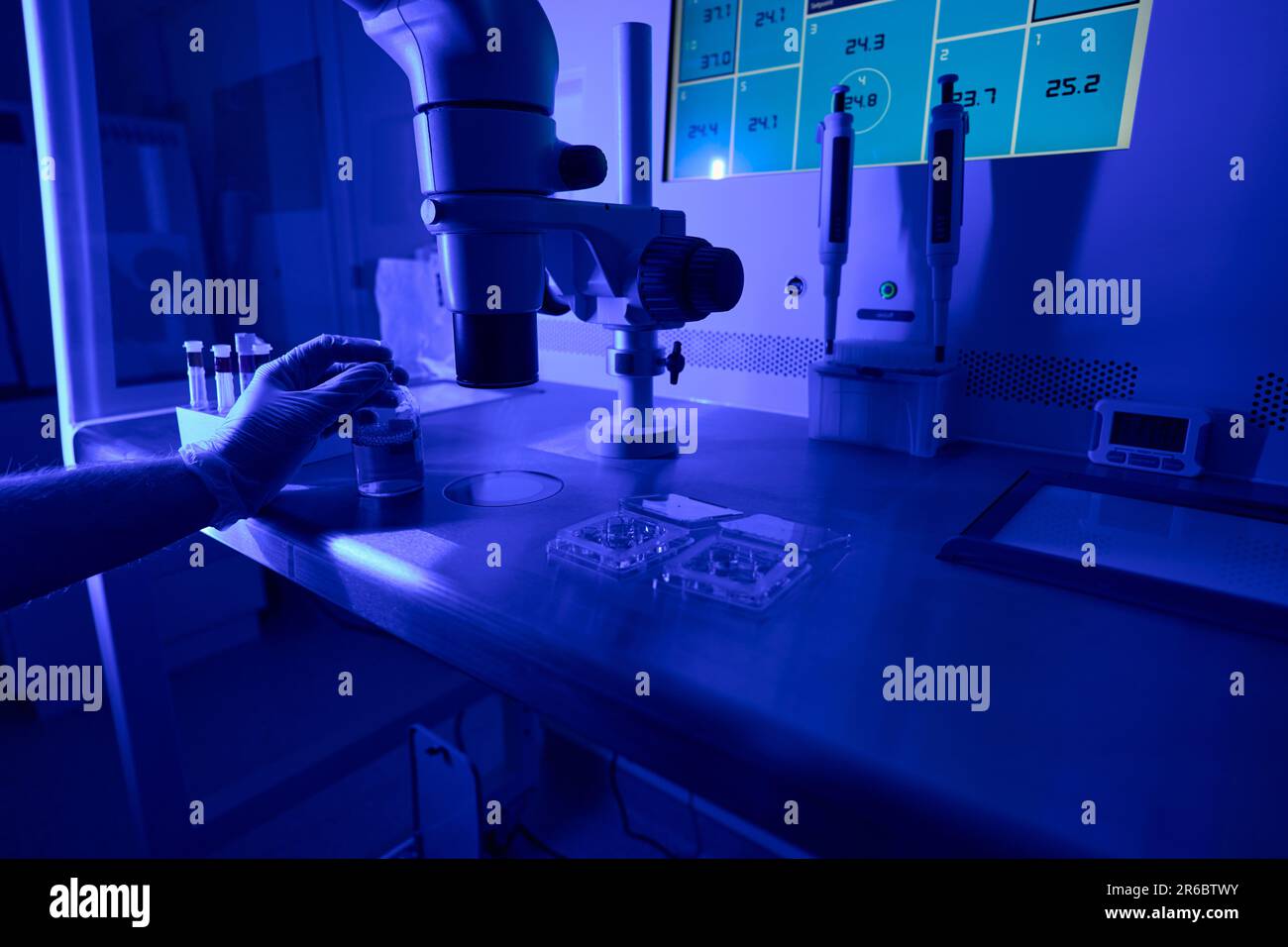Lab technician cleaning workplace after researching under microscope ...