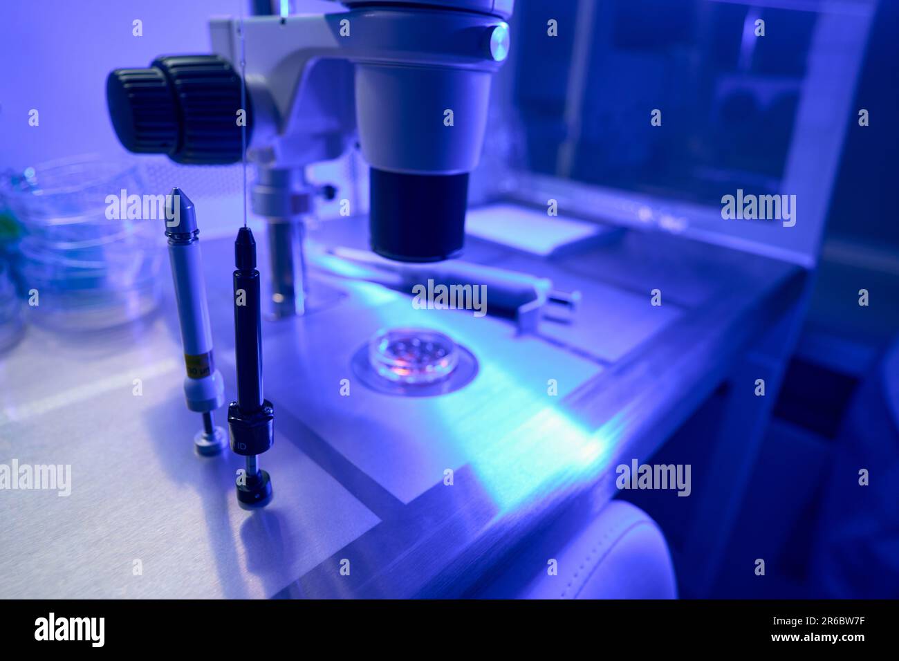 Two syringes for in vitro fertilization standing near microscope Stock ...