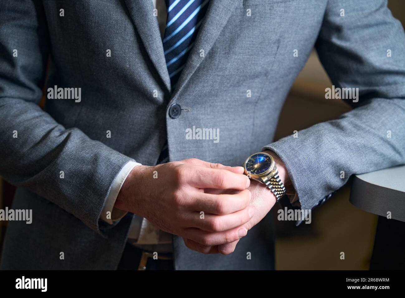 Elegant man with expensive watch on his hand stands reception desk ...