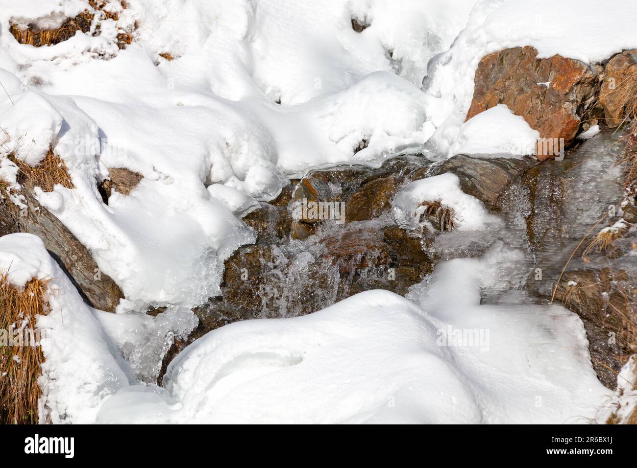 Stream of water flowing on the side of a snowy mountain in Andorra ...