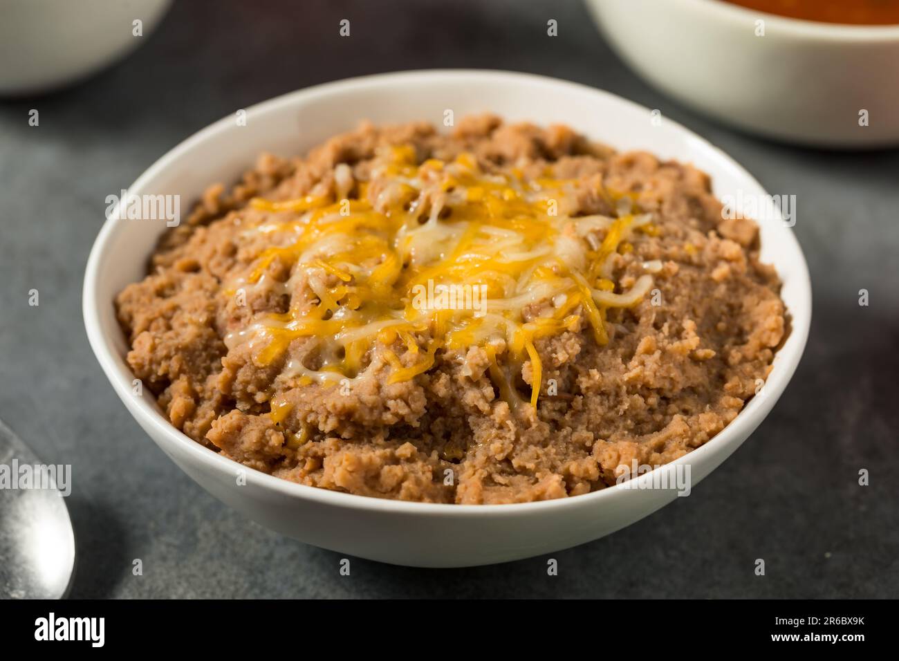 Mexican Homemade Refried Beans with Shredded Cheese Stock Photo - Alamy