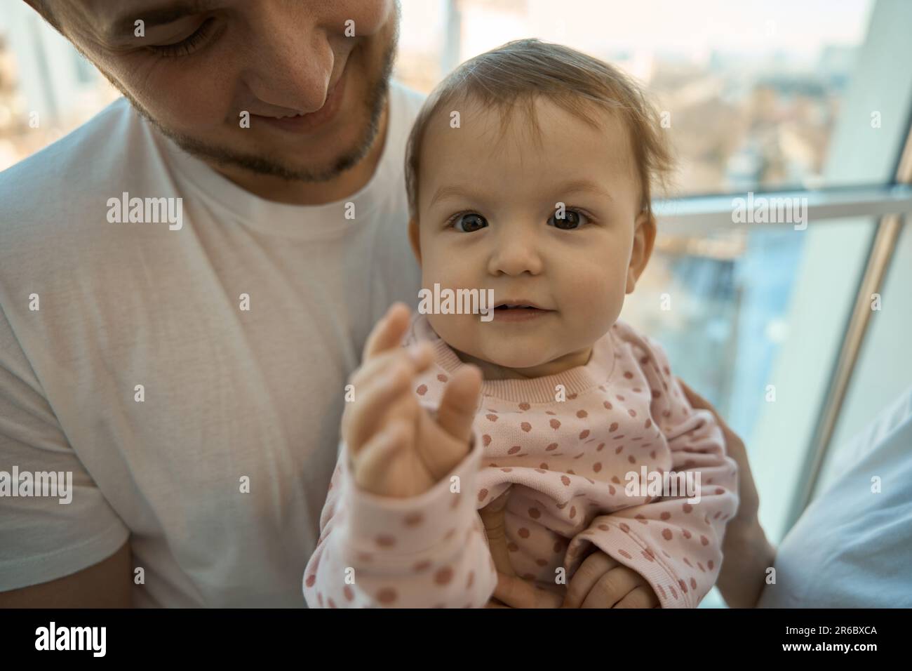 Smiling child with chubby cheeks in the arms of dad Stock Photo - Alamy
