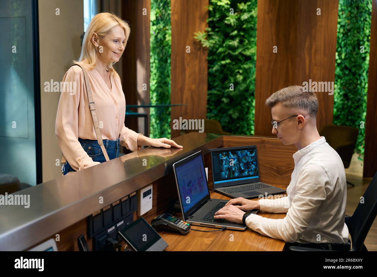 Man employee of beauty salon draws up visitor Stock Photo - Alamy