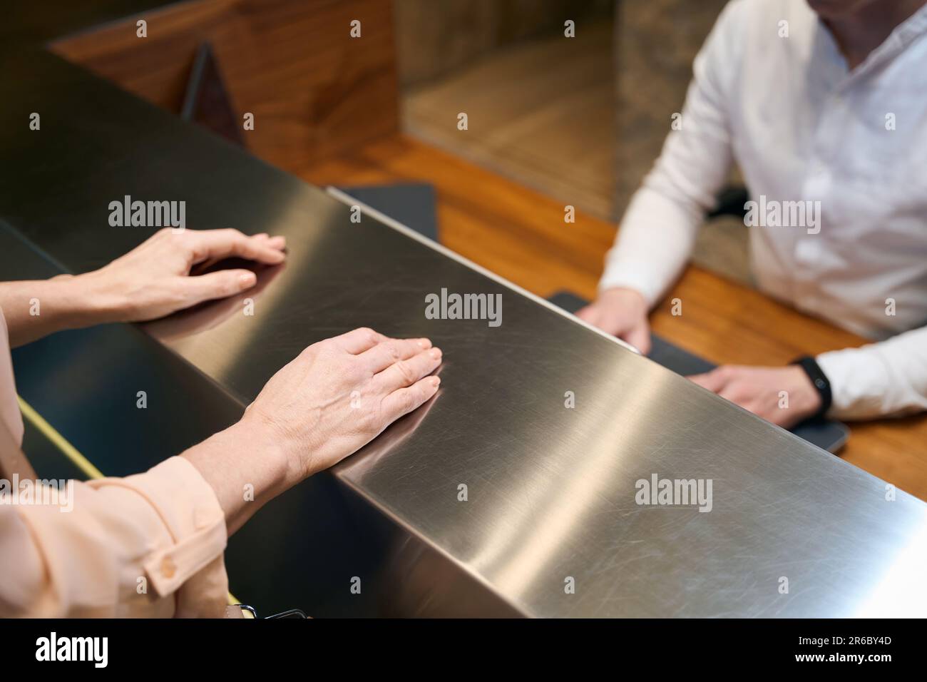 Photo of hands of client and employee at reception desk Stock Photo - Alamy