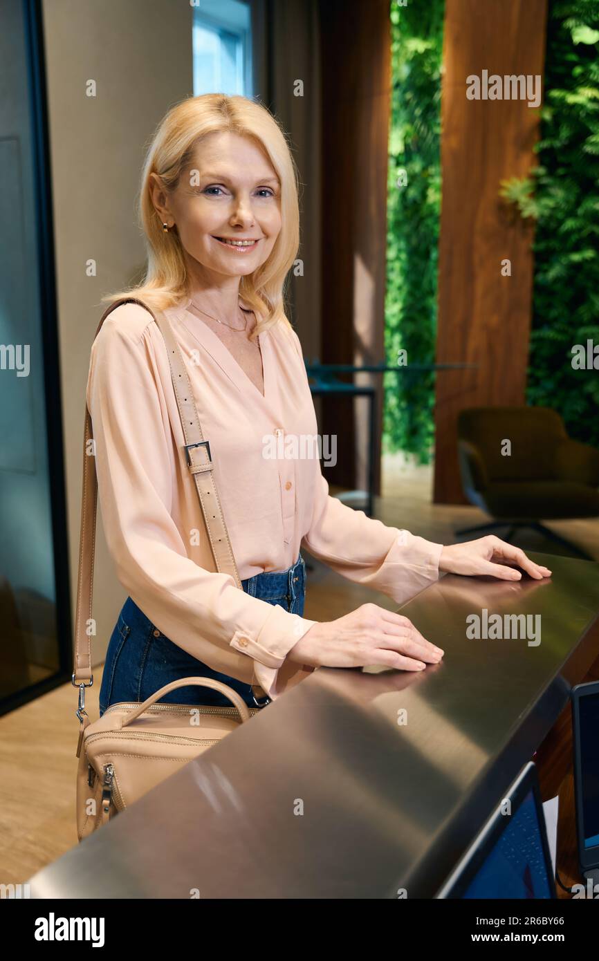 Woman visitor to spa putting her hands on reception desk Stock Photo ...