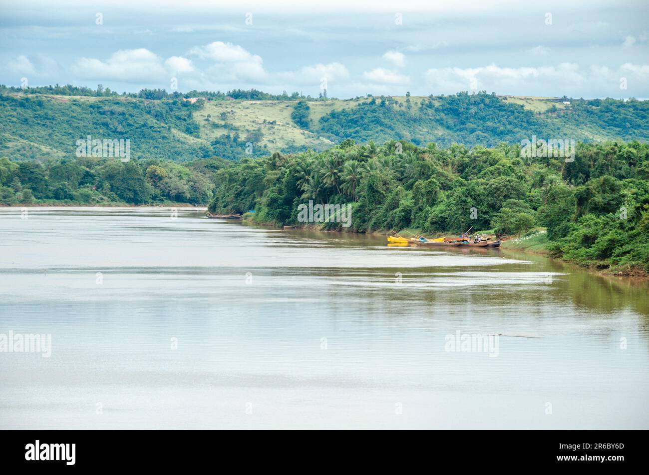 River with lush green river bank and muddy rain water at Polali ...