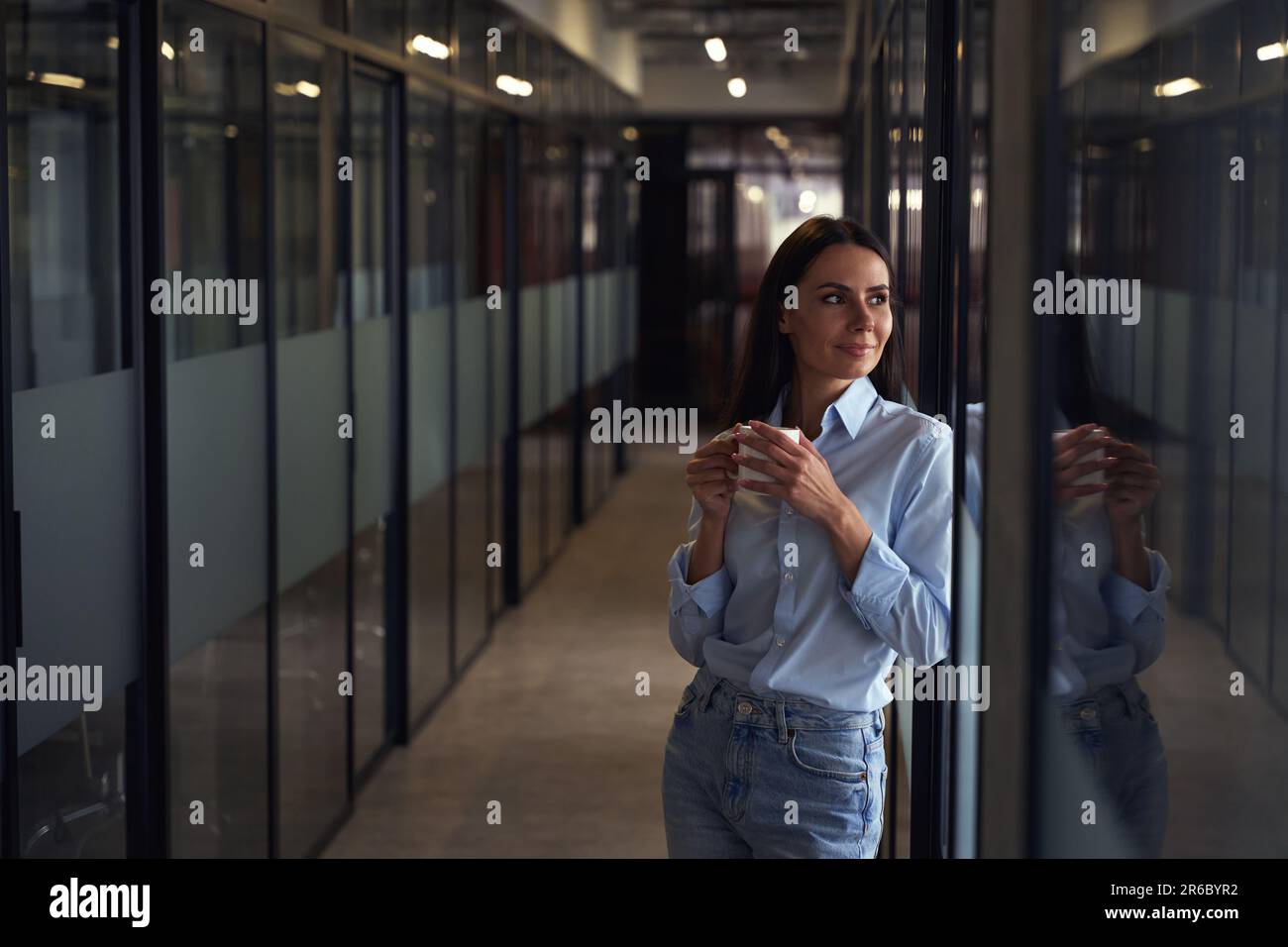 Thoughtful company employee daydreaming in office hallway during tea ...