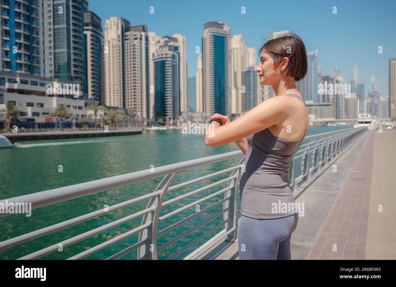 Young Asian female runner watch on heart rate monitor wrist watch band ...