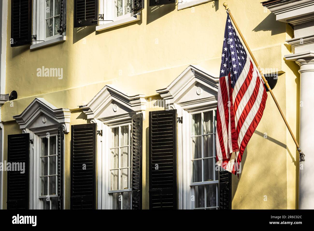 An American flag hanging outside of a colonial era home in Charleston ...