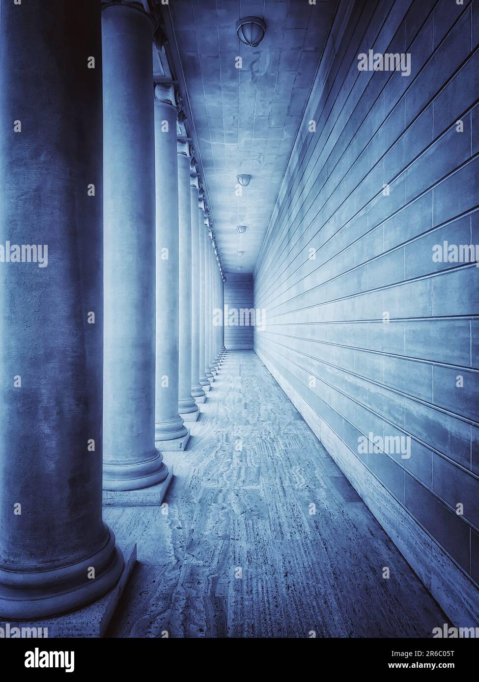 Long and narrow hallway with tall columns and concrete wall Stock Photo ...