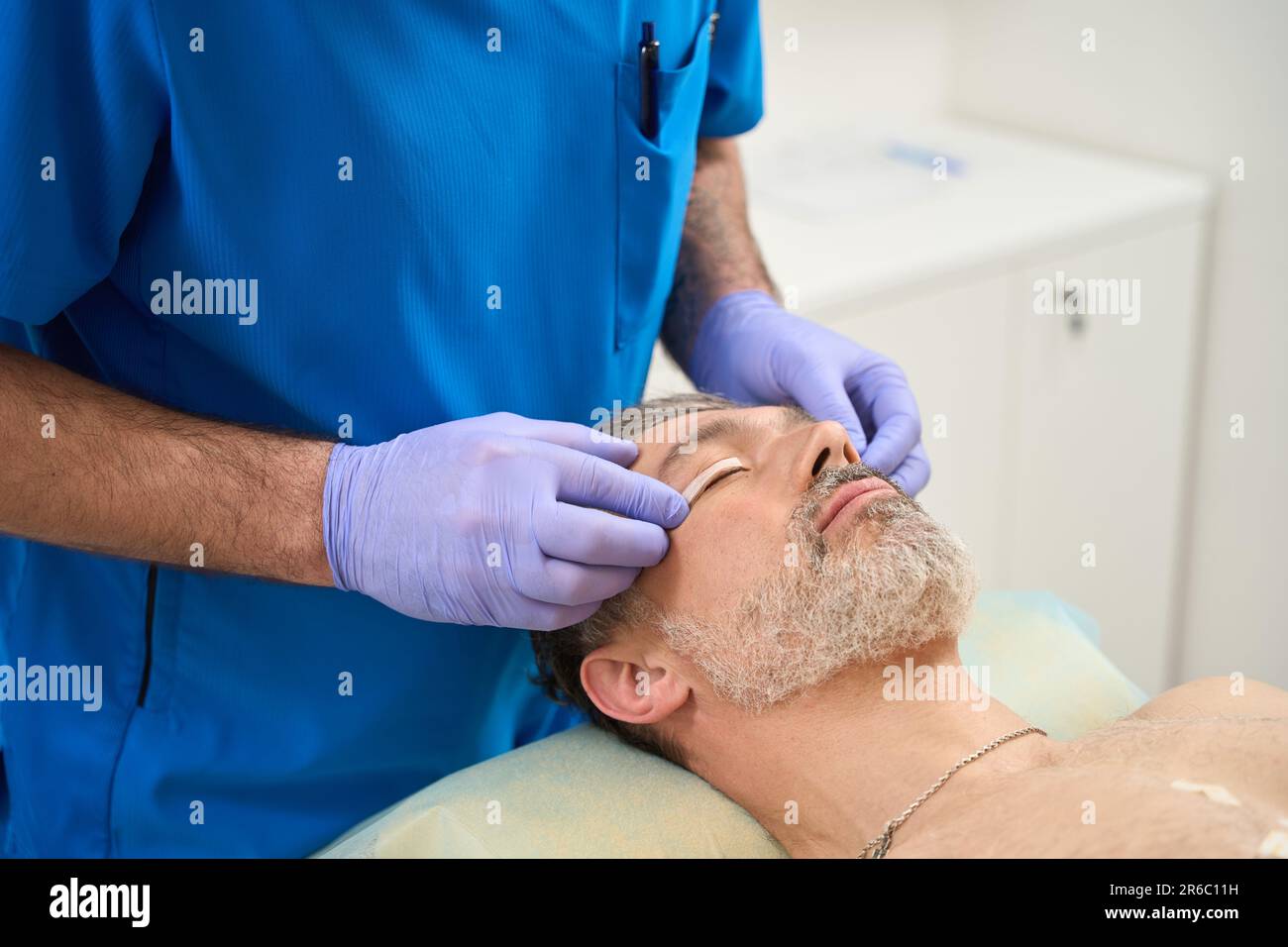 Doctor hands glued plaster to male patient for impending eyelids Stock ...
