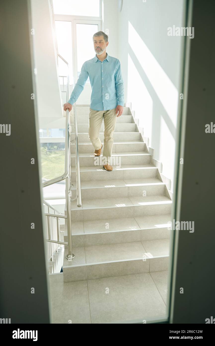 Male patient going down steps in hallway of the hospital Stock Photo ...