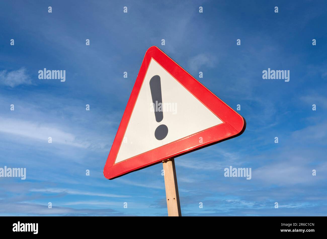 Warning road sign with exclamation mark, against a blue sky background ...
