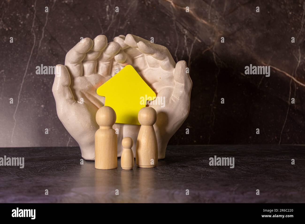 Housing for families. Close up of wooden figurines of family with ...