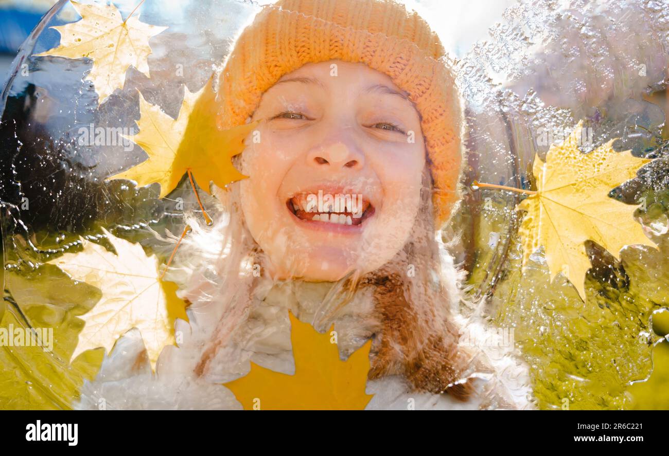 Girl kid girl behind ice with autumn leaves. Bright yellow orange maple ...