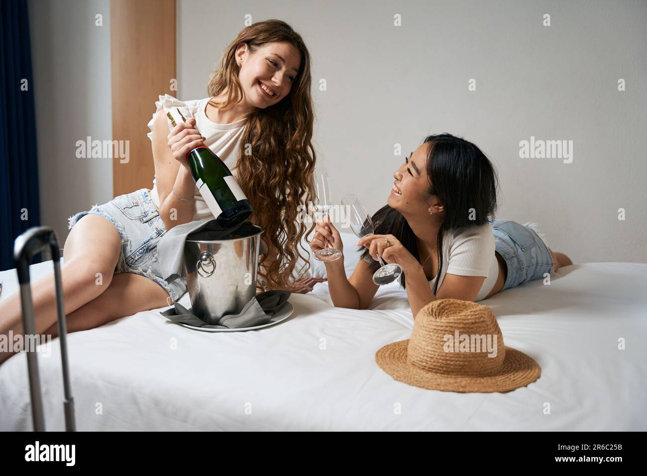 Two friends celebrating a trip in a hotel room Stock Photo - Alamy