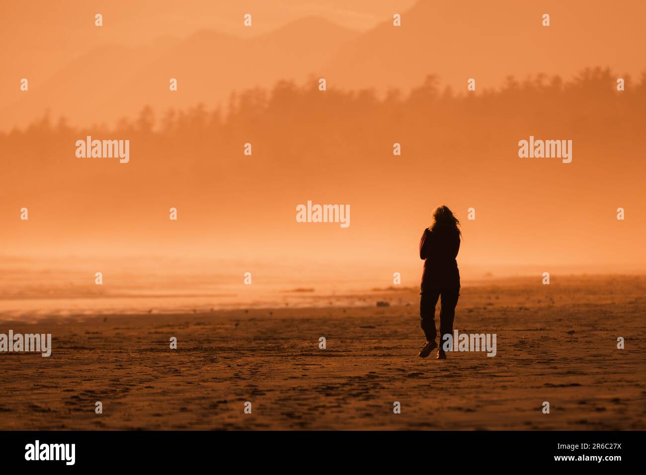 A woman walks alone at Long Beach in the Pacific Rim National Park ...