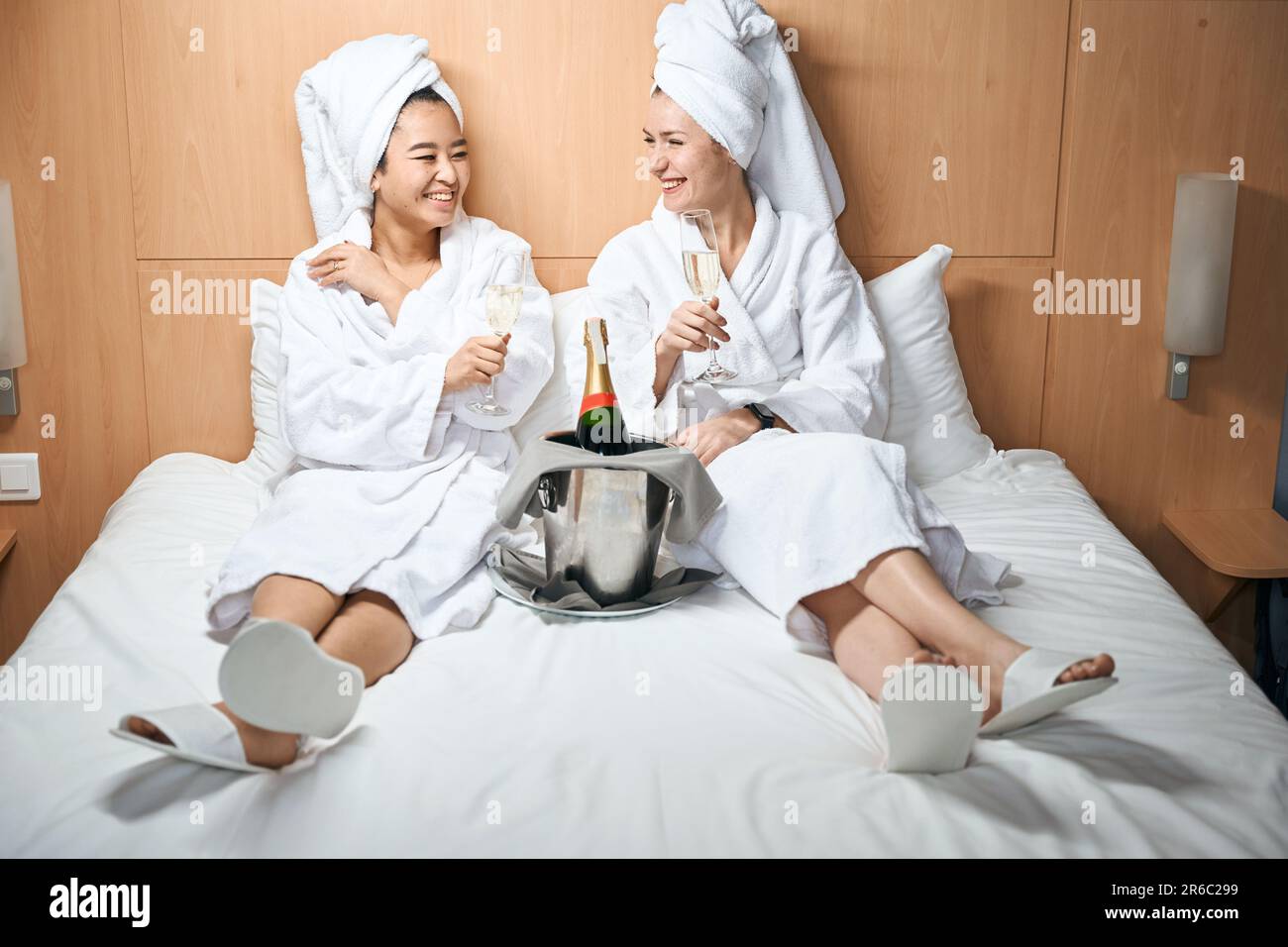 Two ladies in bathrobes drink champagne in a hotel room Stock Photo - Alamy
