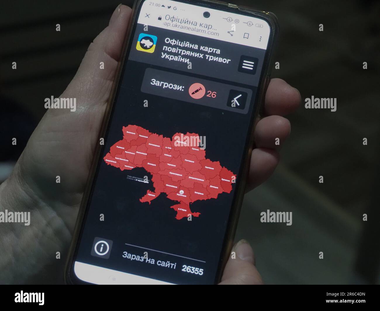 A smartphone in a woman's hands with the Official Map of Air Alerts in ...