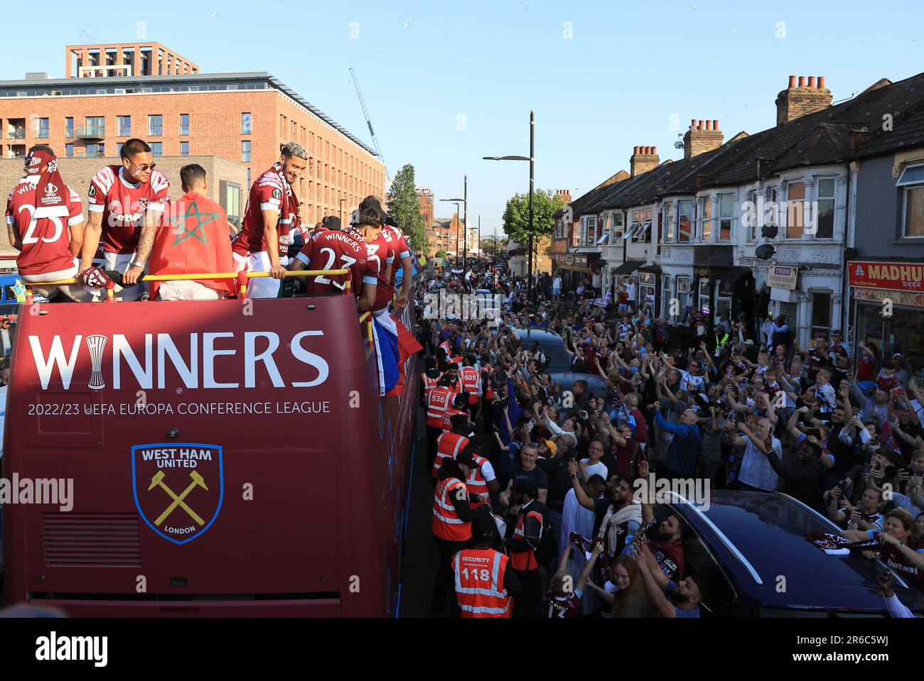 West Ham United fans line the street as an open top bus with the team ...