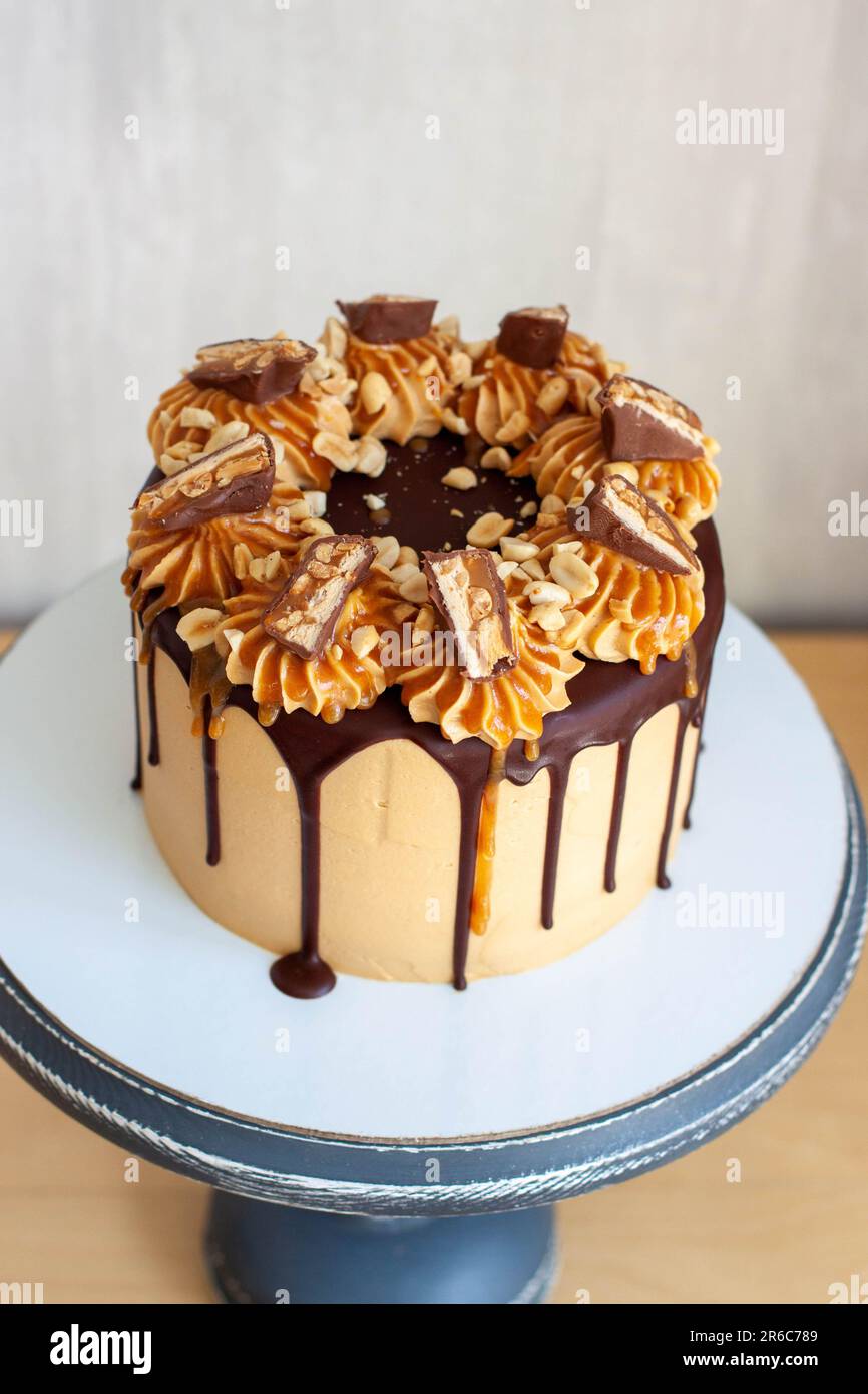 Snickers cake with peanut butter cream, melted chocolate, candy bars ...