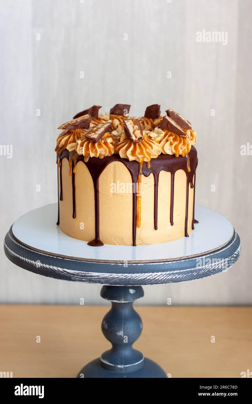 Snickers cake with peanut butter cream, melted chocolate, candy bars ...