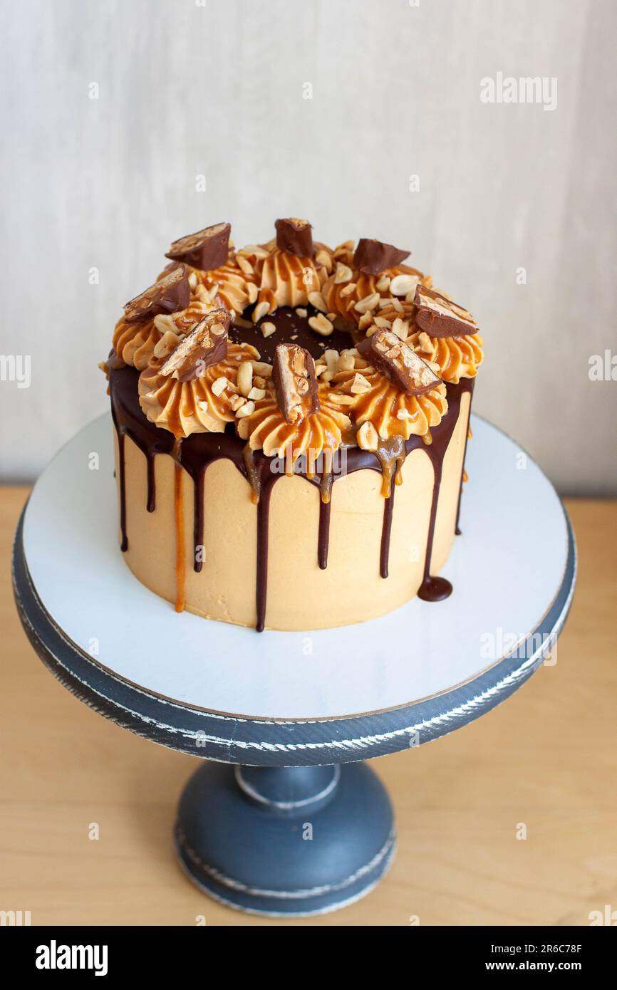 Snickers cake with peanut butter cream, melted chocolate, candy bars ...