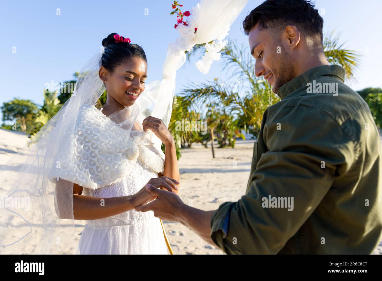 Bride and groom both wearing white on the beach hi-res stock ...