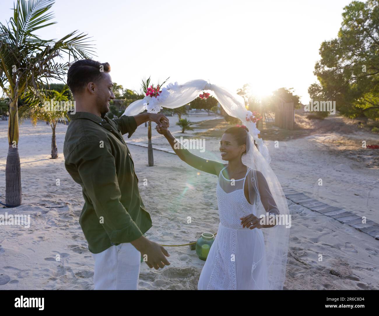 Caucasian newlywed couple holding hands and dancing at wedding ceremony ...