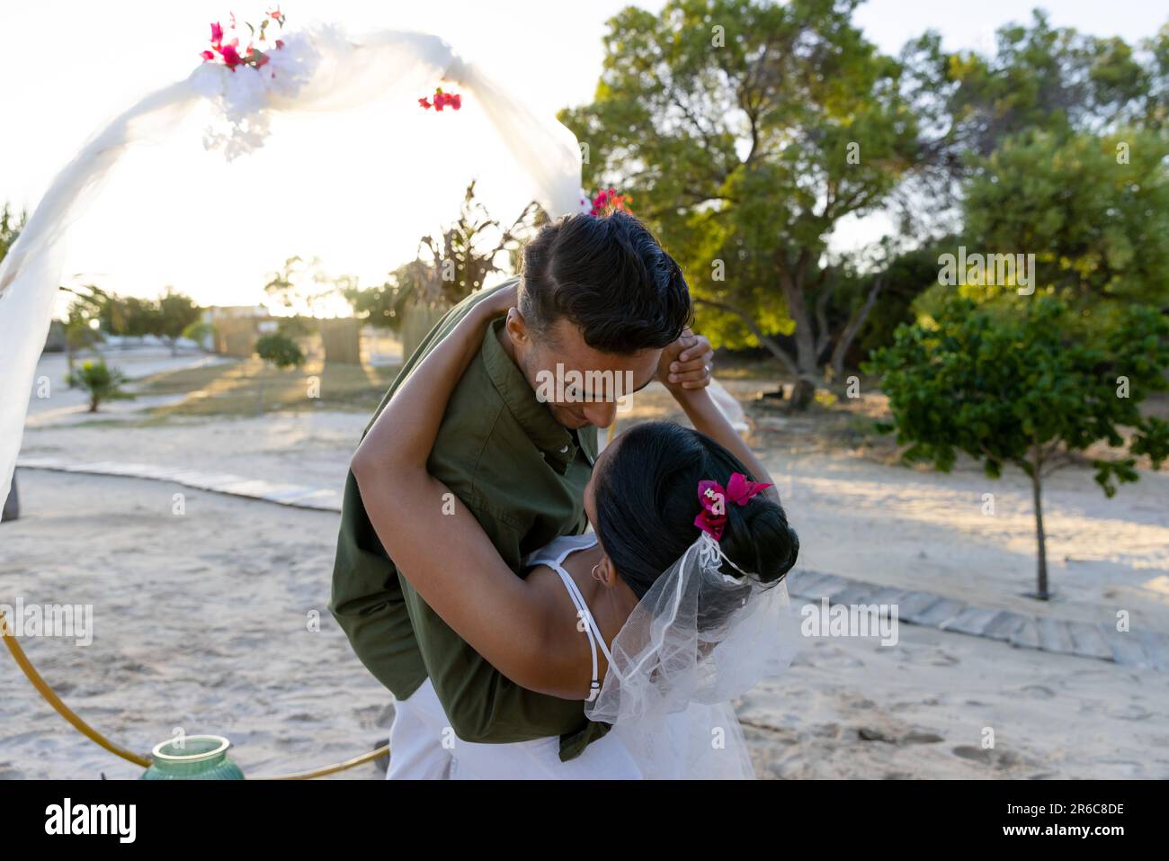 Caucasian newlywed couple dancing at wedding ceremony at beach during ...