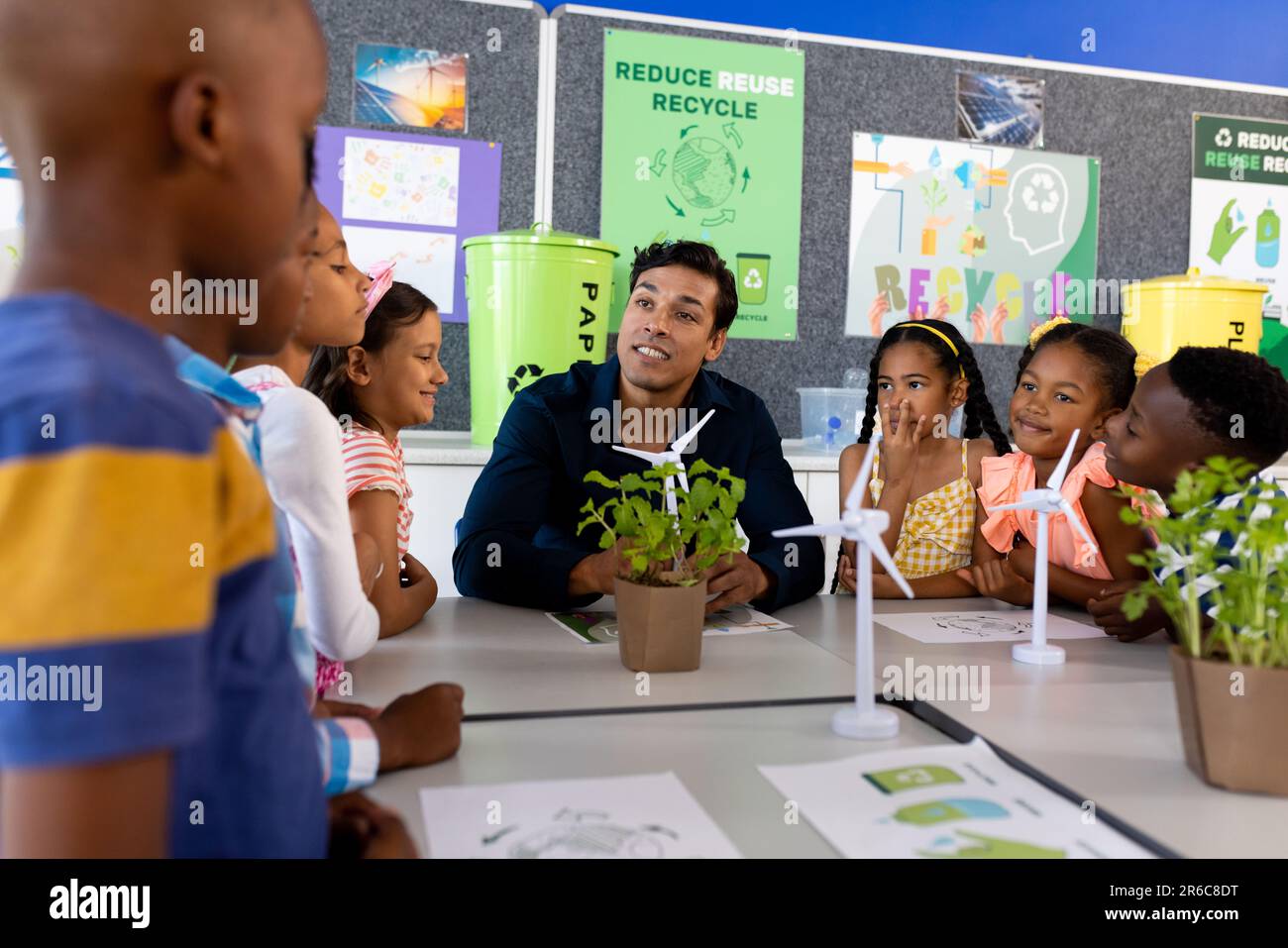 Happy diverse male teacher and children in elementary school class with ...