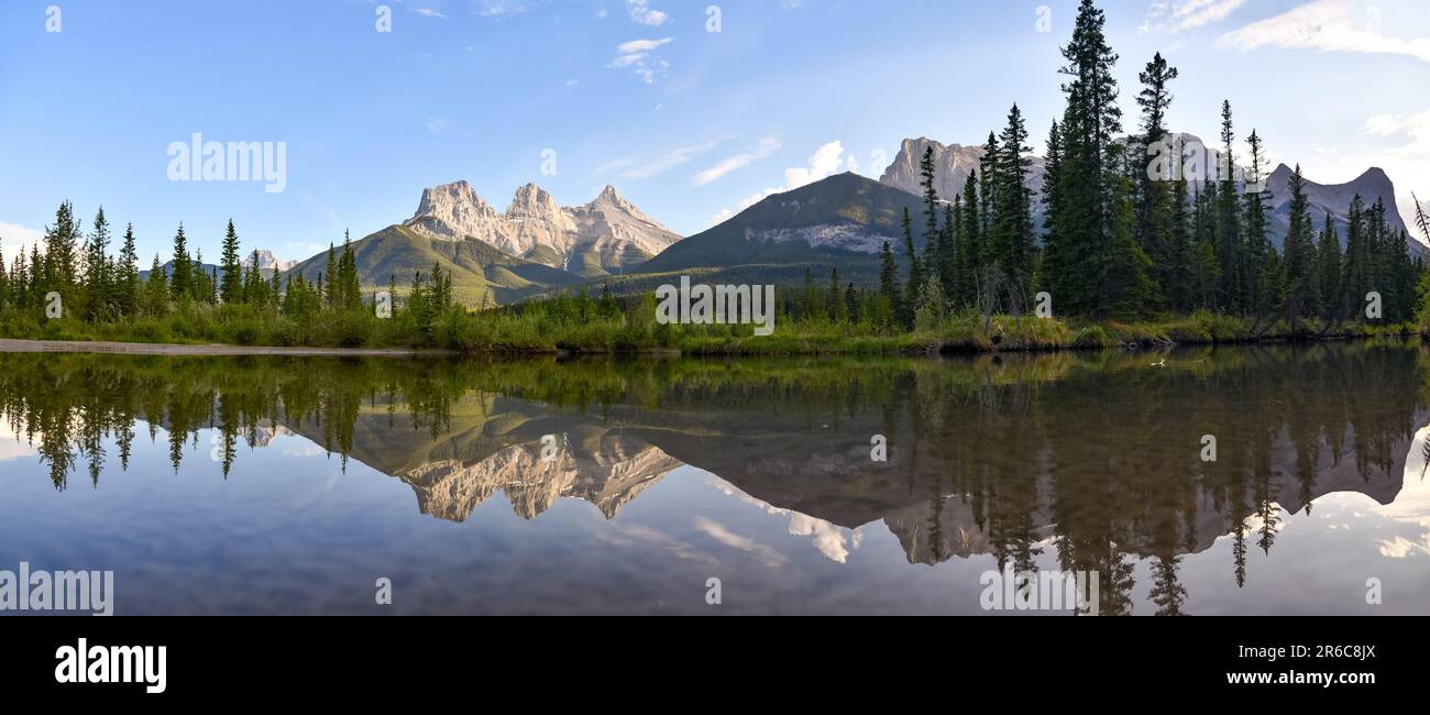 Mountain peaks reflecting in the calm water below at Three Sisters in ...