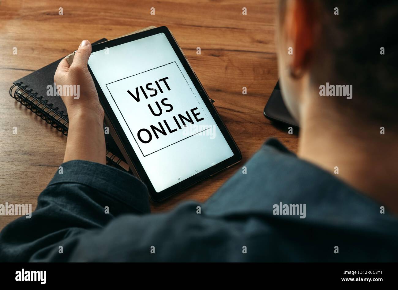 Business concept. A woman holds a tablet in her hands on the screen of ...