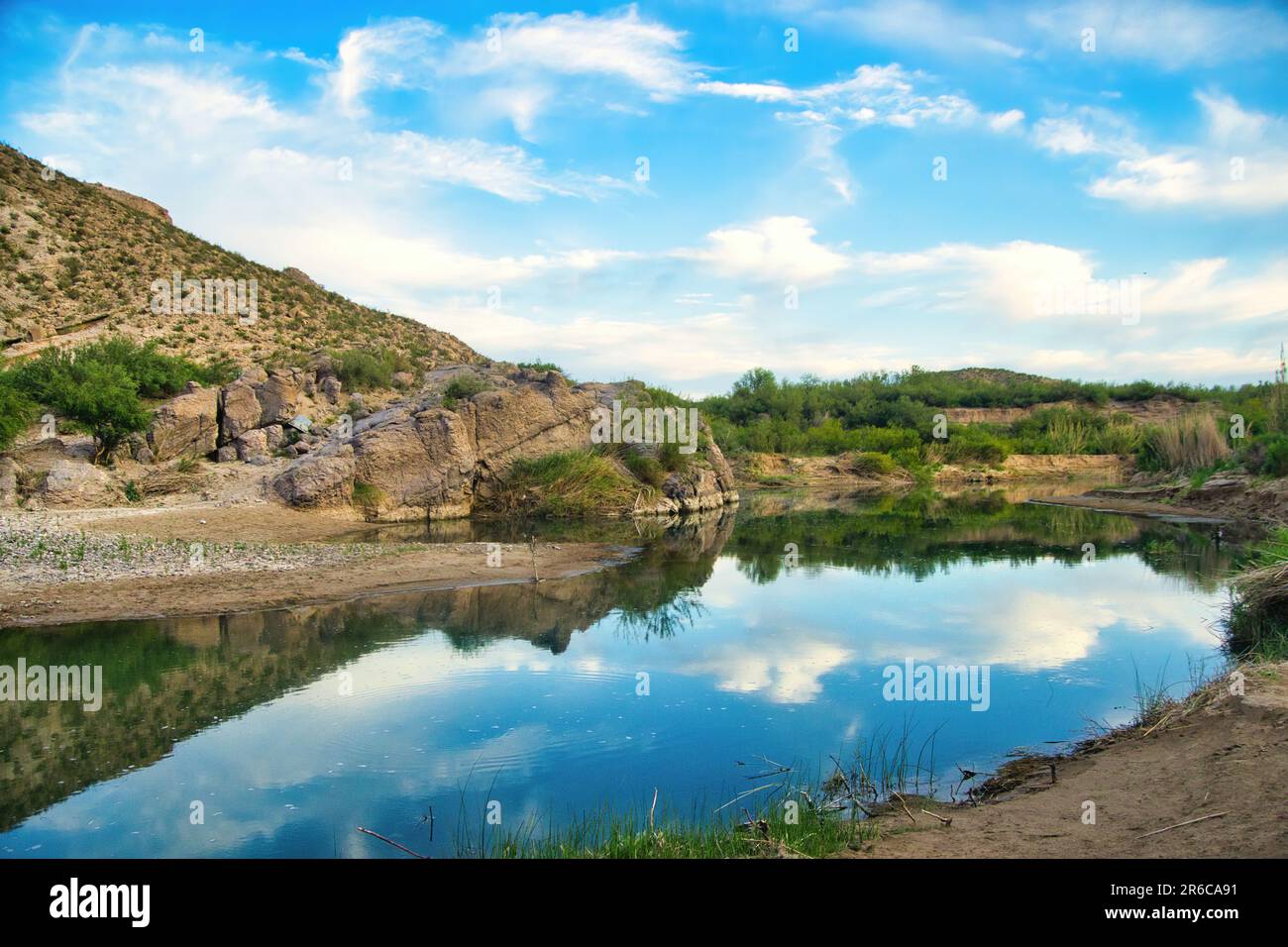 The glassy surface of a stream reflects the desert surroundings at Big ...