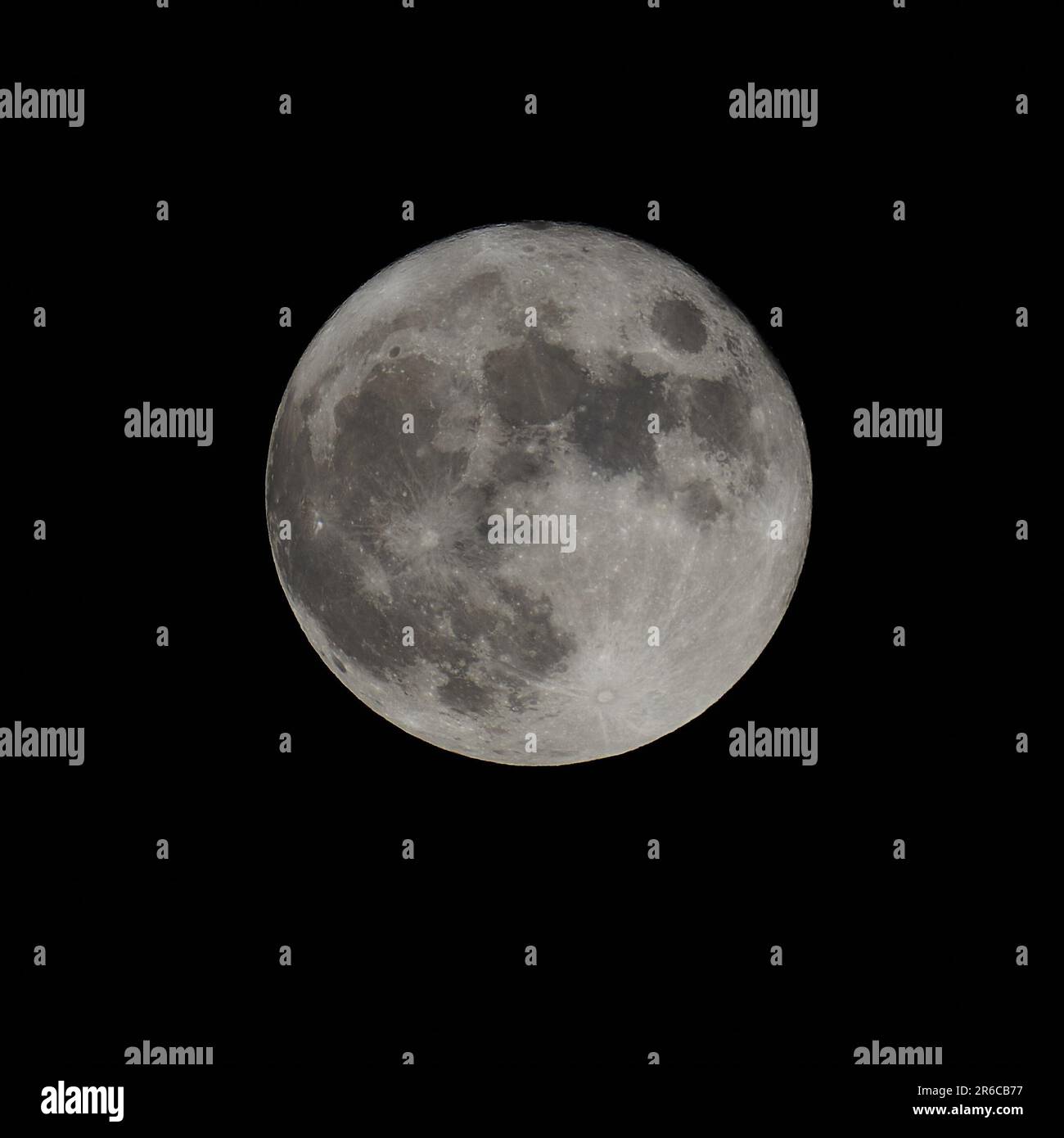 A stunning full moon illuminates the inky black night sky, creating a ...