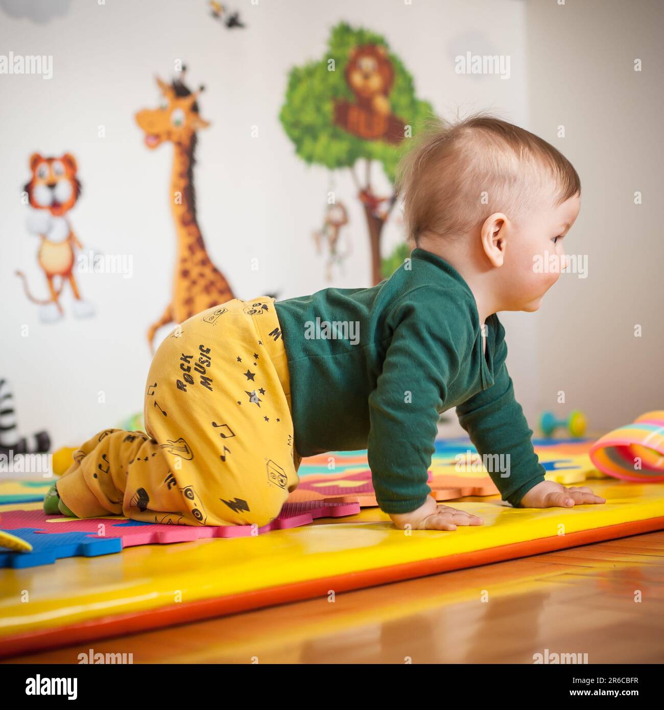 Cute baby boy crawls on the home floor, explore the world and learn to ...
