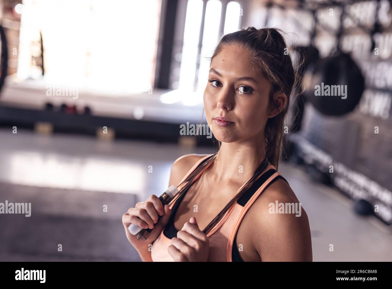 Portrait of confident caucasian young female boxer with skipping rope ...