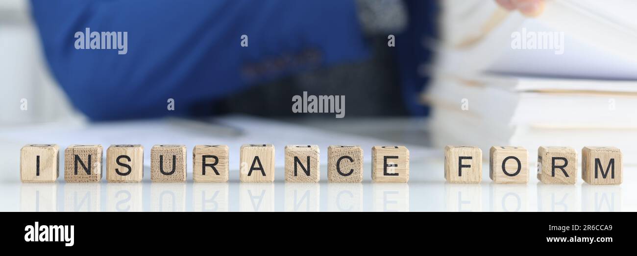 Man with insurance claim form, word collected of wooden cubes Stock ...