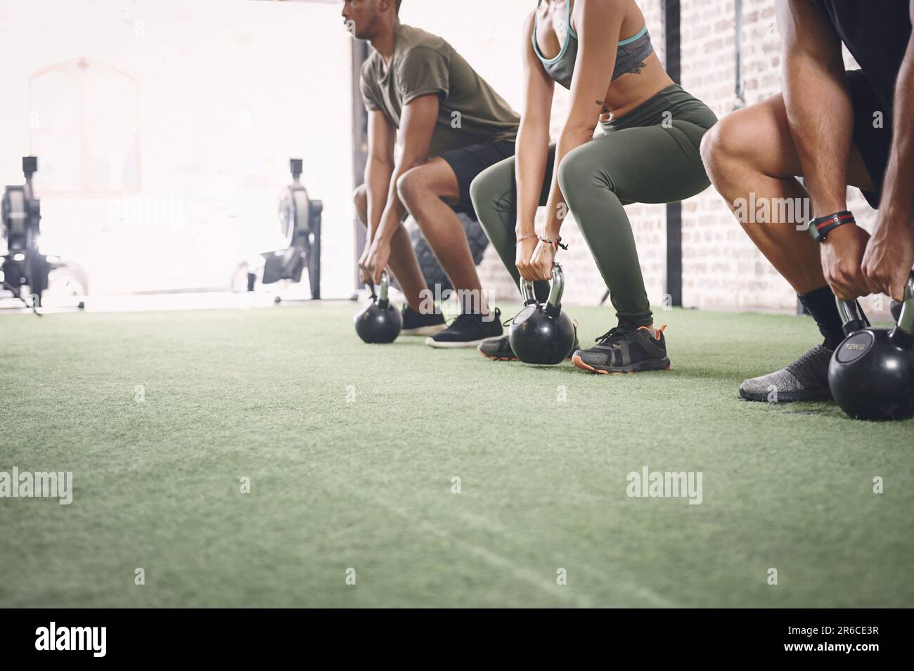Action is key to all success. a fitness group holding kettlebells while ...
