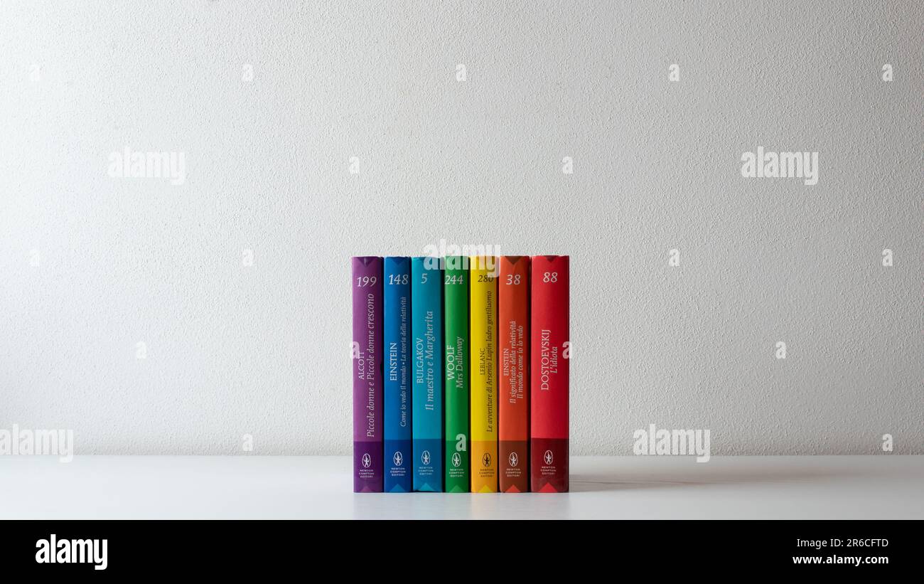 Six books of varying colors, placed side by side in a neat row, with ...