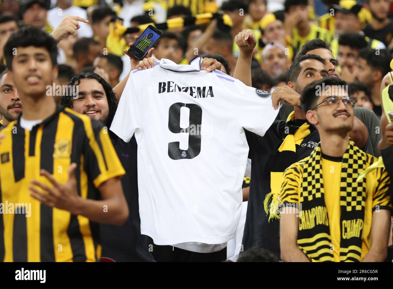Saudi Al Ittihad soccer fans wave by a T-shirt of their team player ...