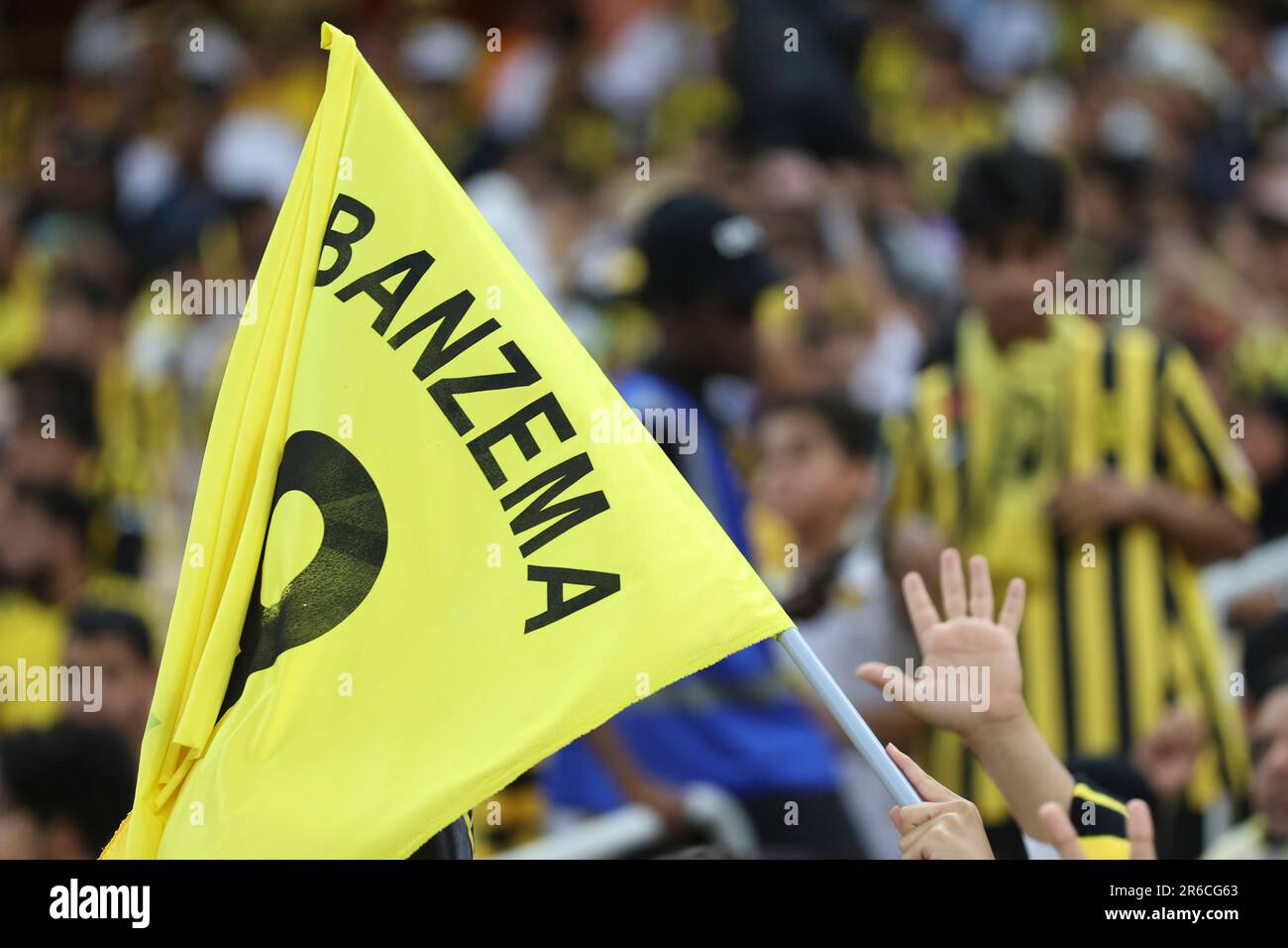 Saudi Al Ittihad soccer fans wave a flag with the name their new team ...
