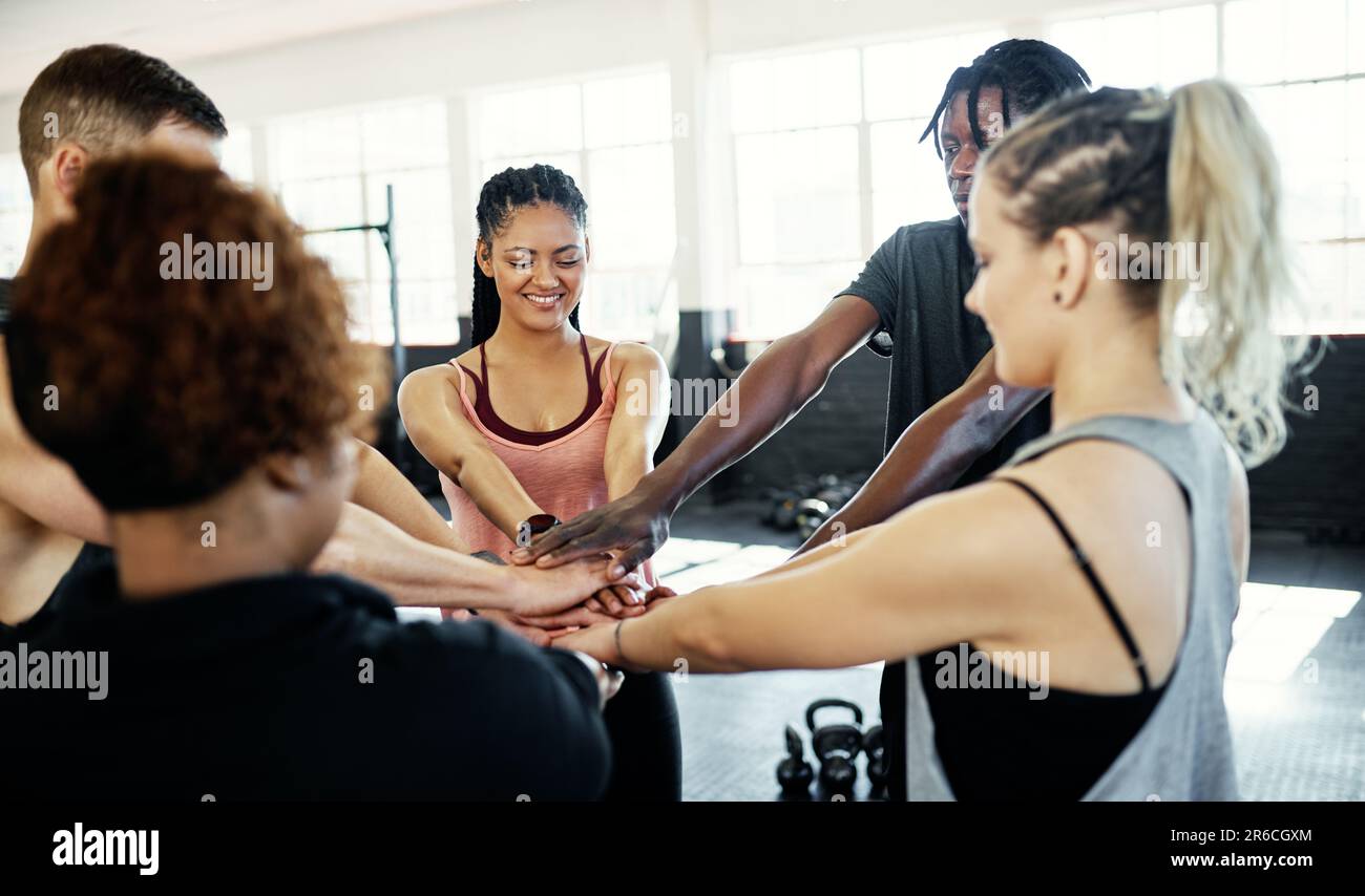 Stack one by one. a cheerful young group of people forming a huddle ...